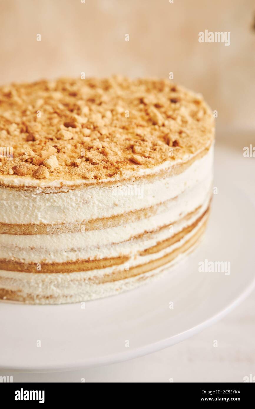 Closeup of a layered cake with cream and a crumb topping on a tray on ...