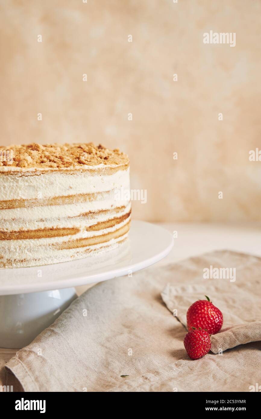 Closeup of a layered cake with cream and a crumb topping on a tray on ...