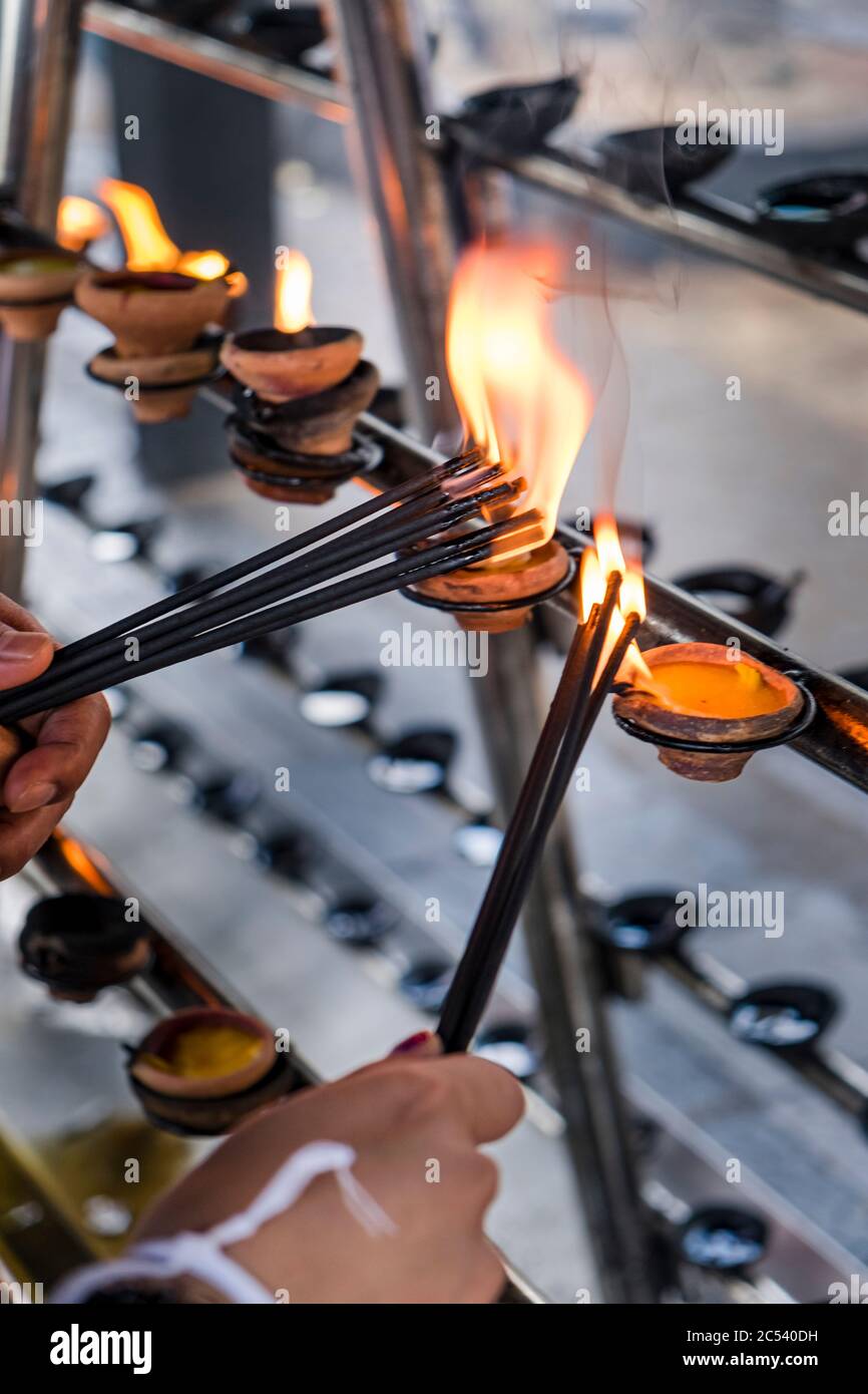 Buddhist ritual, lighting clay oil lamps and incense sticks, Sri Lanka ...