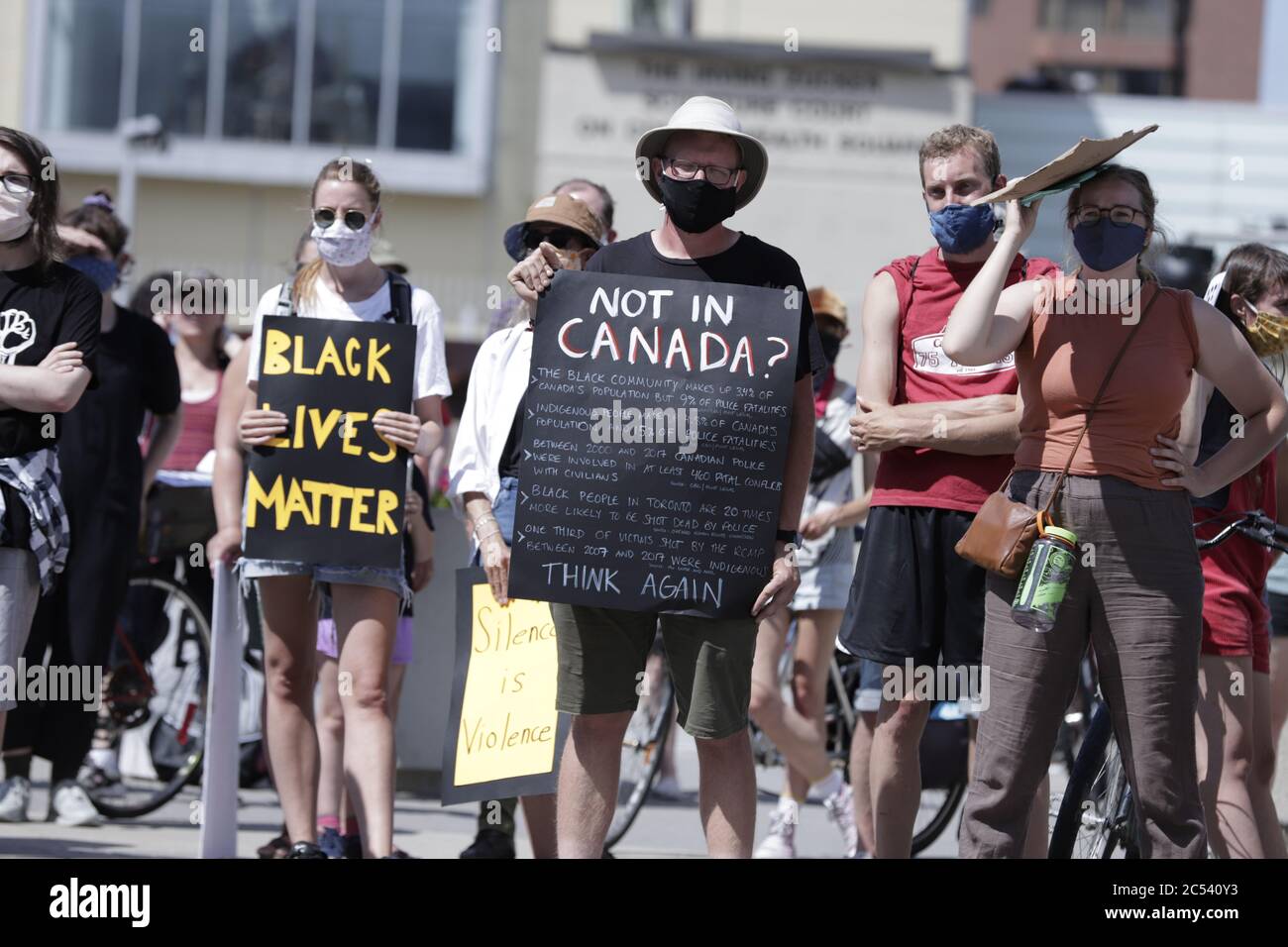 Canadian protesters march and hold up posters along the streets to ...