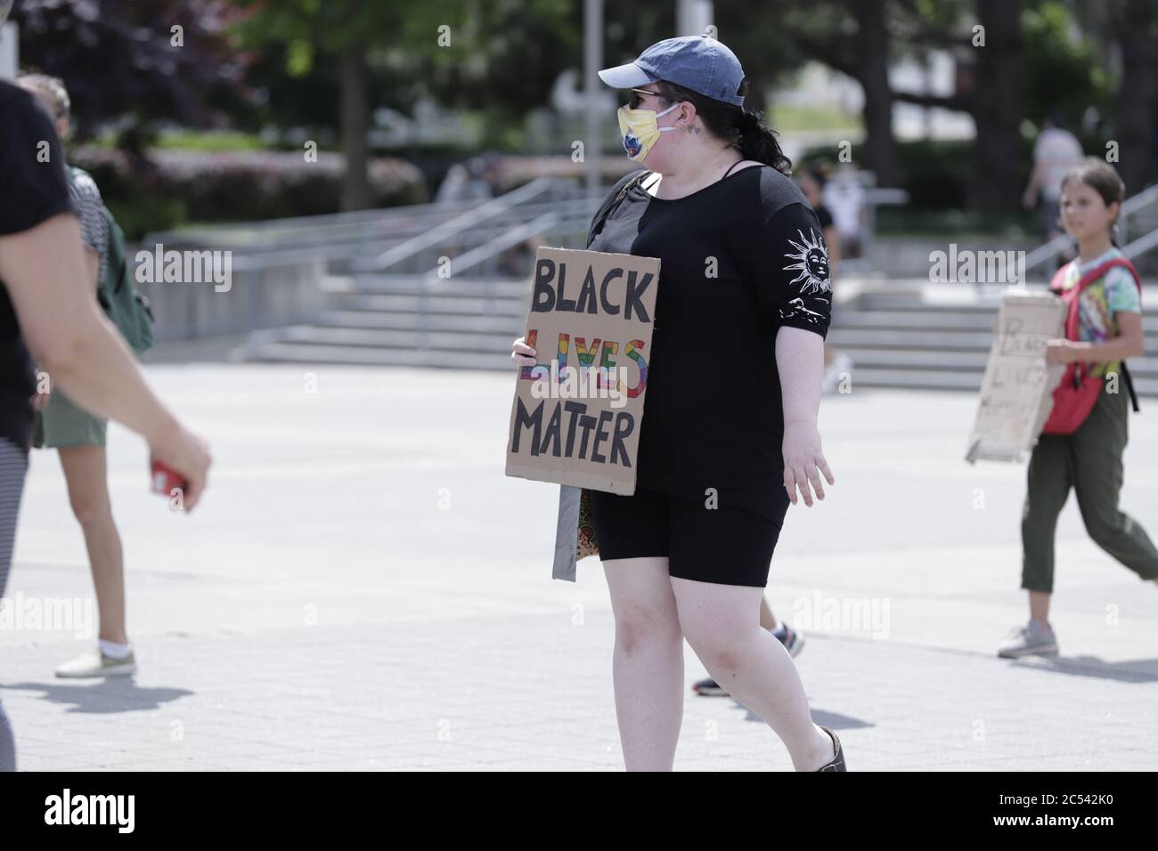 A woman seen marching in the midst of the crowd holding up a placard in ...