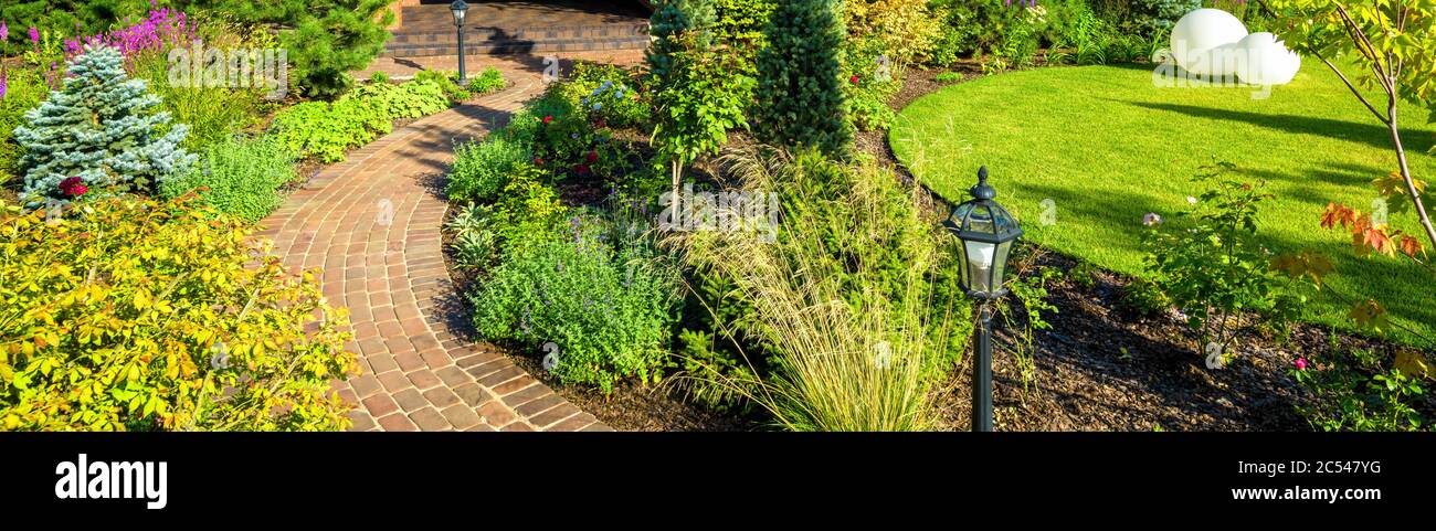 Landscaping in nice green garden in summer. Panoramic view of ...