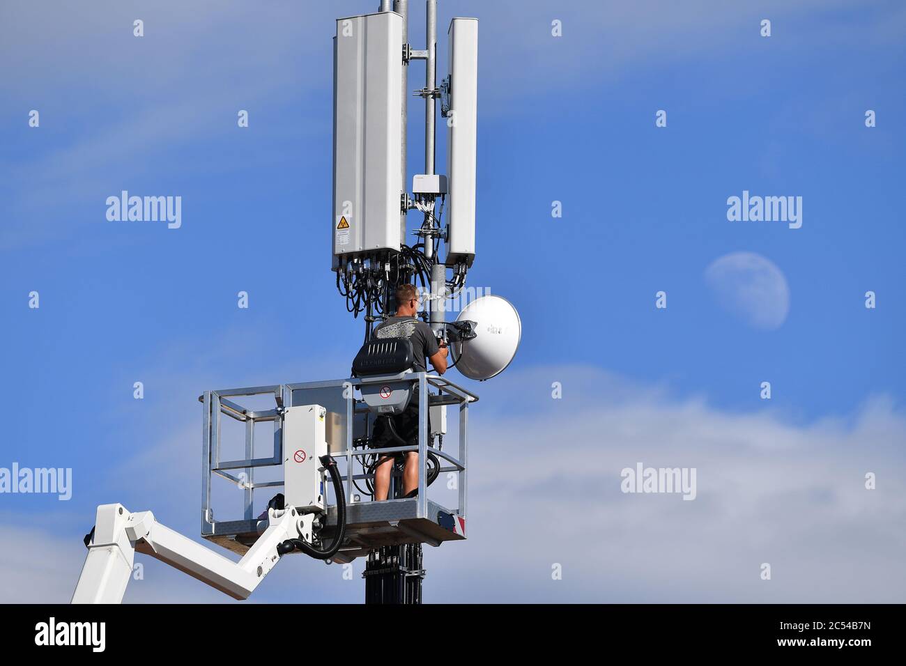 Hair, Deutschland. 30th June, 2020. Cell tower on a house roof. Worker ...