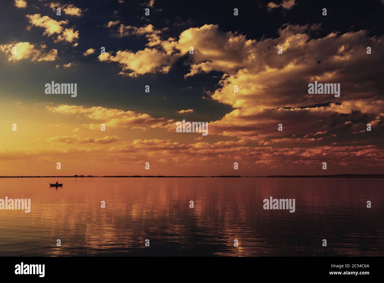 Sunset in the Volga River Delta. A riverscape with a fishing boat ...