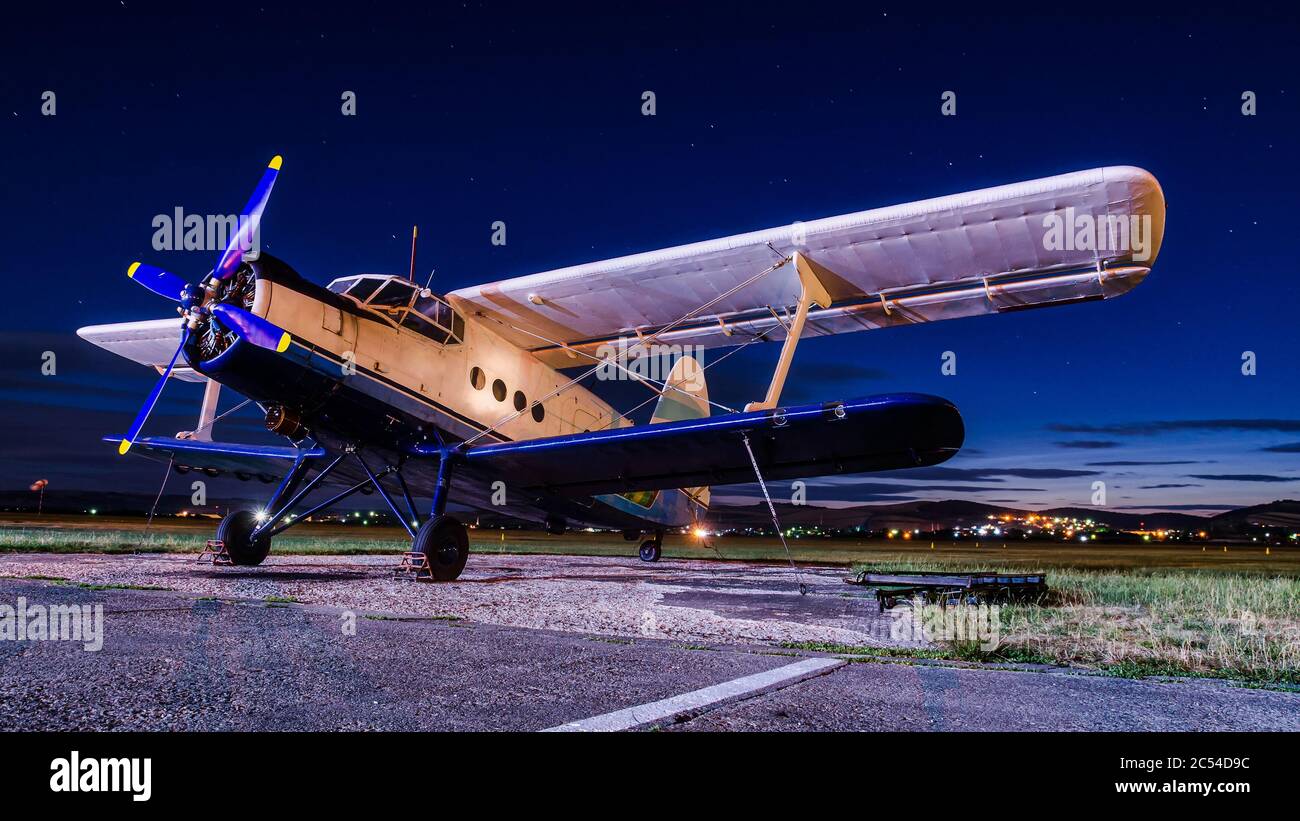 Old vintage classic airplane on small airfield in night time with clear ...