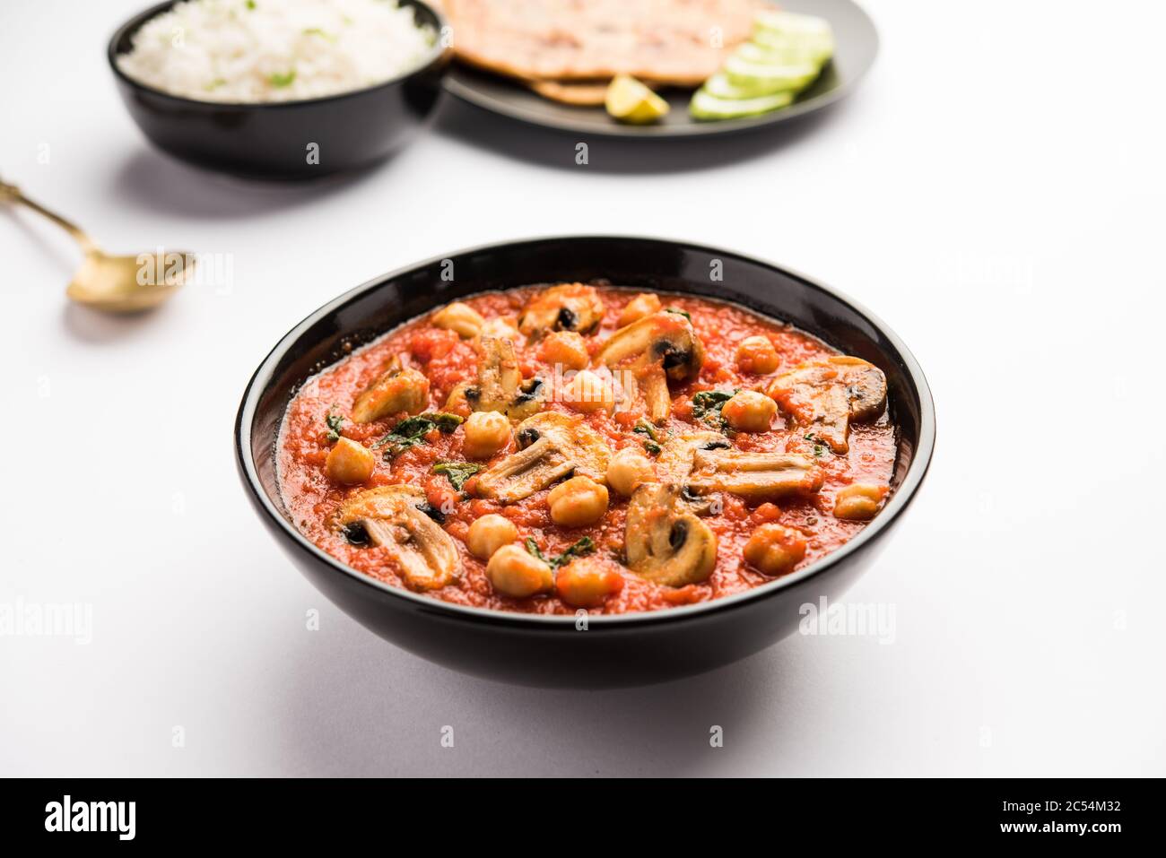 Mushroom sabzi in tomato curry with chickpea and spinach, Indian main ...