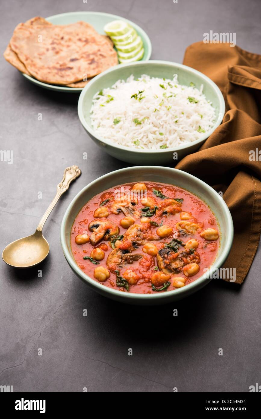 Mushroom sabzi in tomato curry with chickpea and spinach, Indian main ...