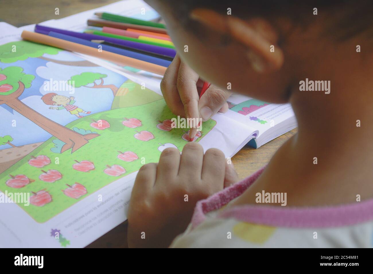 Closeup shot of a girl coloring a picture book using a red pencil Stock ...