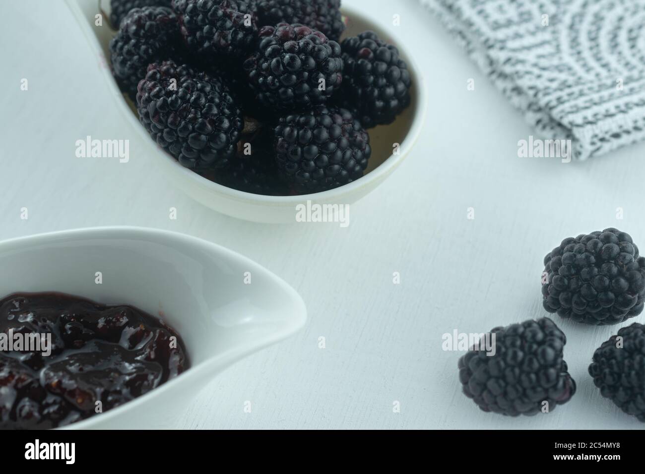 Closeup shot of fresh ripe blackberries and blackberry jam on the table ...