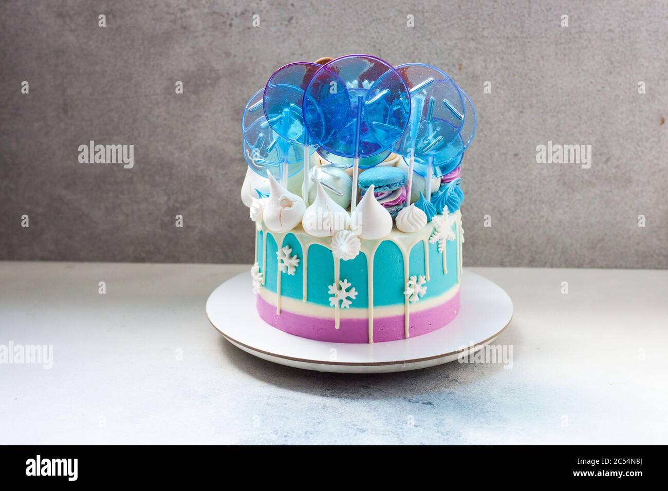 Blue winter cake with white chocolate, lollipops and fondant snowflakes ...