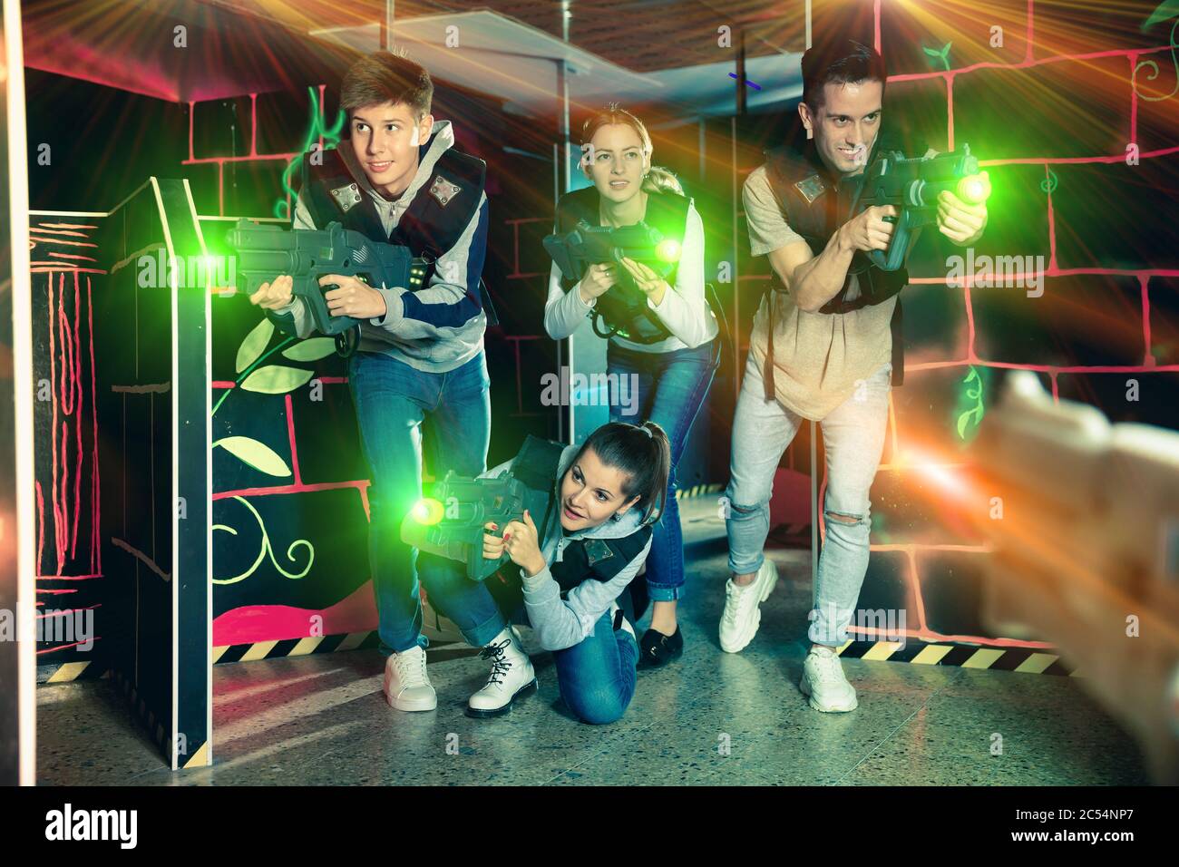Modern pleasant cheerful positive people with laser pistols playing ...