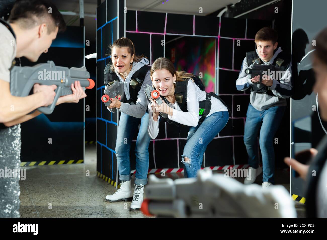 Young women with laser gun having fun on dark lasertag arena Stock ...