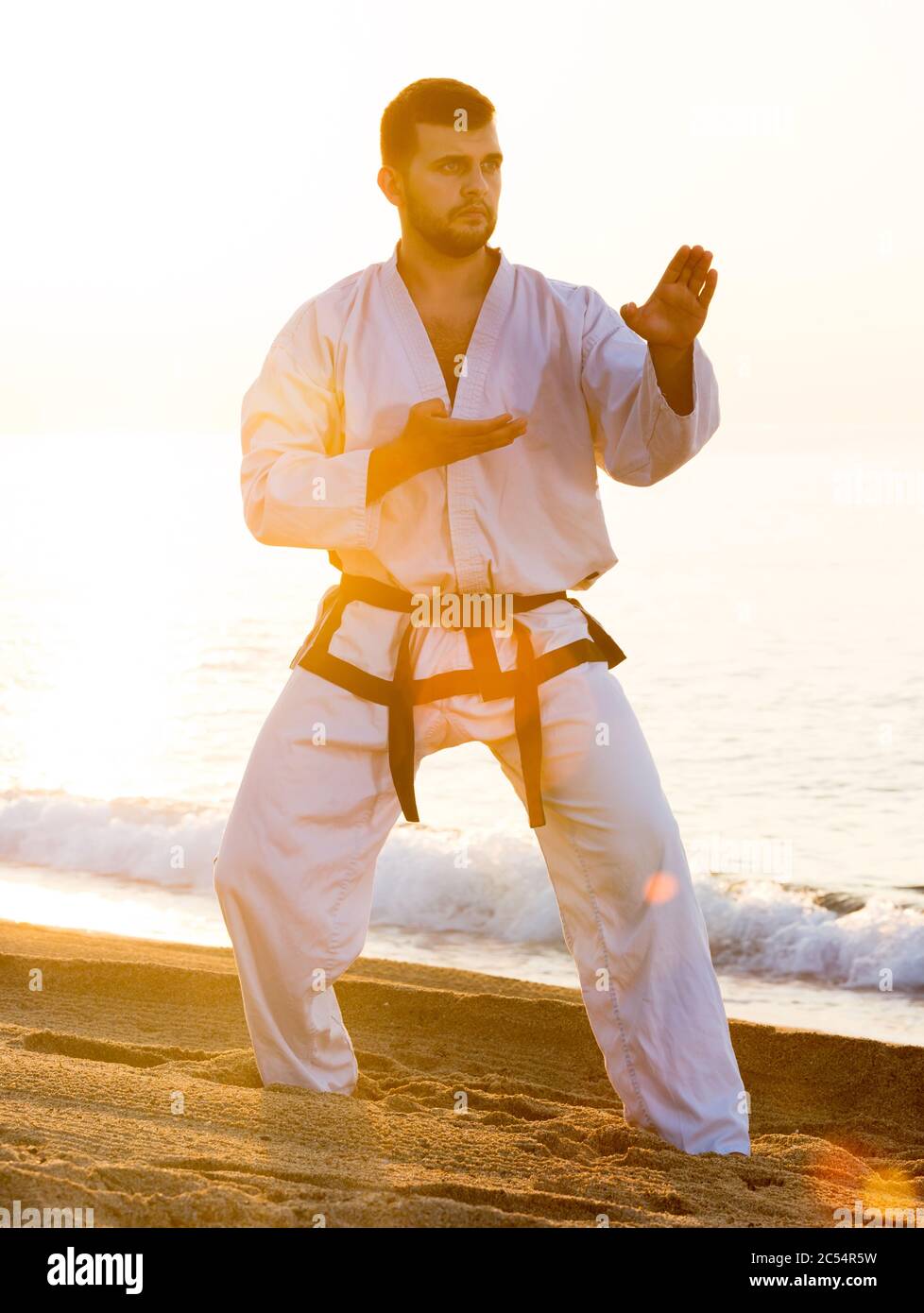 Young guy practising karate poses at seaside in sunrise outdoor Stock ...