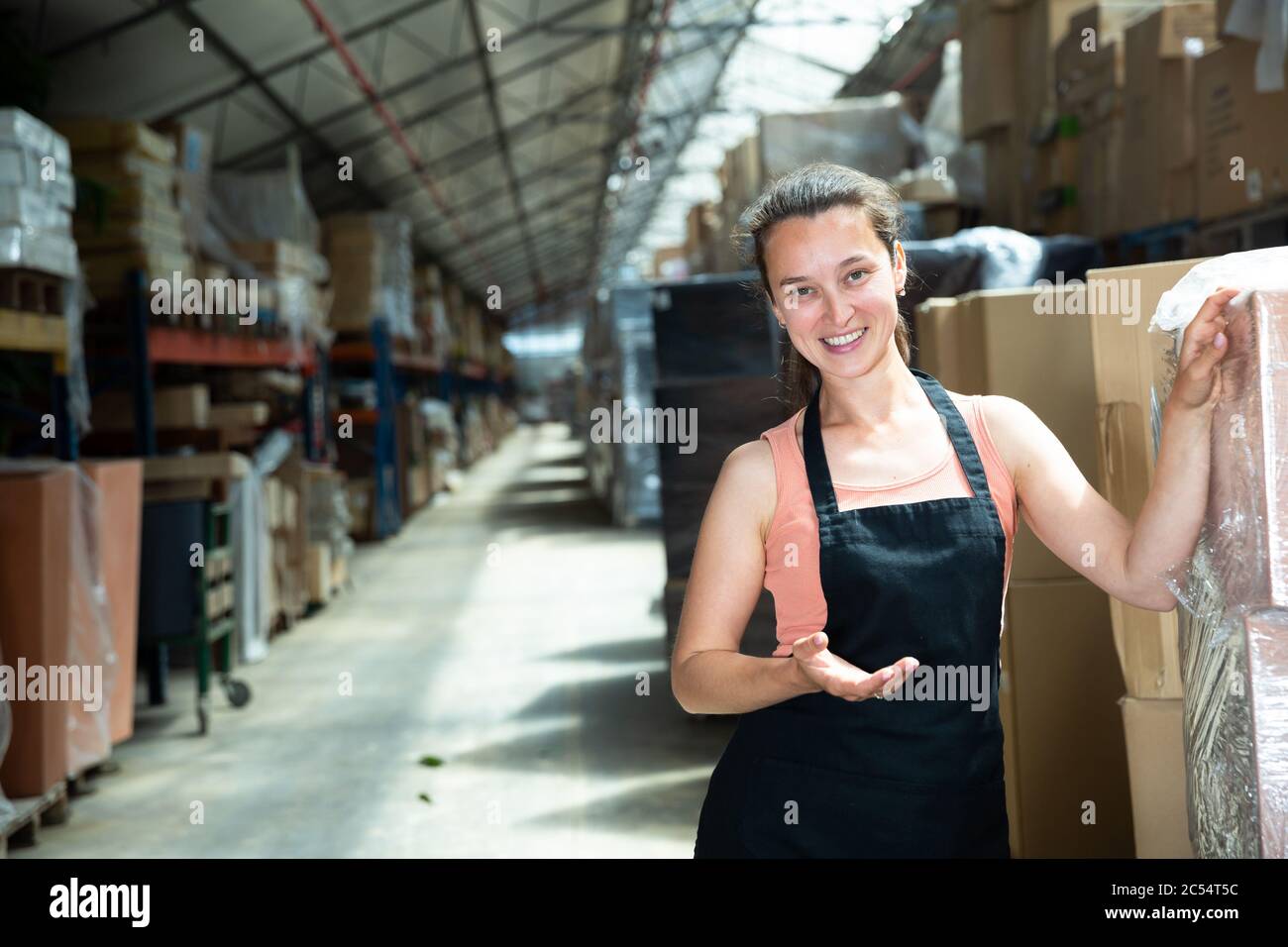 Portrait of female worker in apron with arms crossed standing in ...