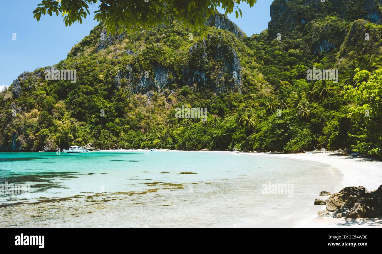 A beautiful empty tropical beach with huge limestone hills and jungle ...