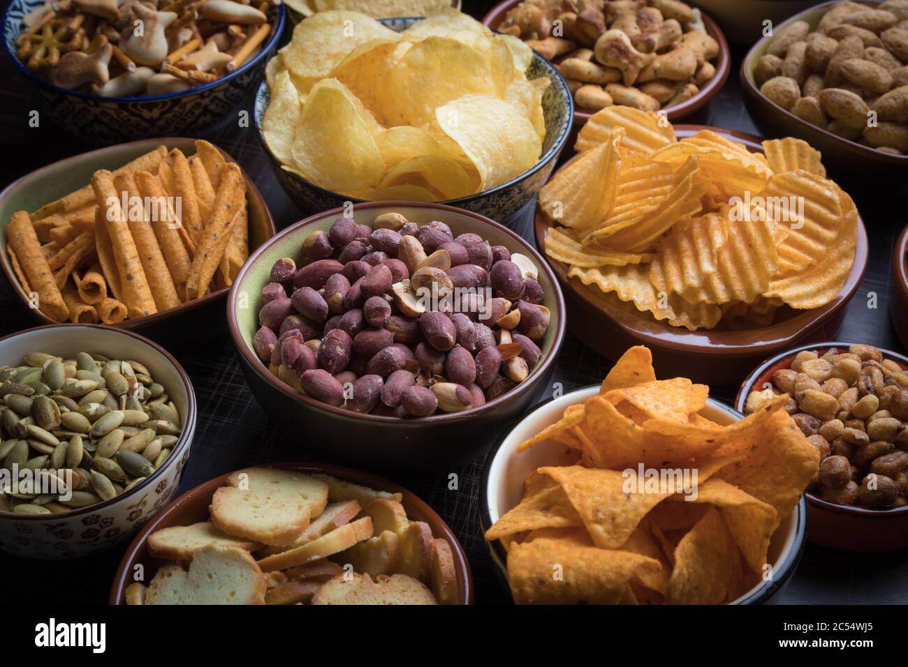 Salty snacks served as party food in ceramic bowls Stock Photo - Alamy