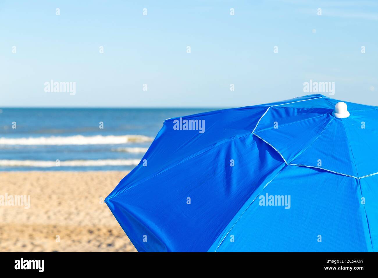 Travel and beach vacations concept. Blue parasol on the beach in a ...