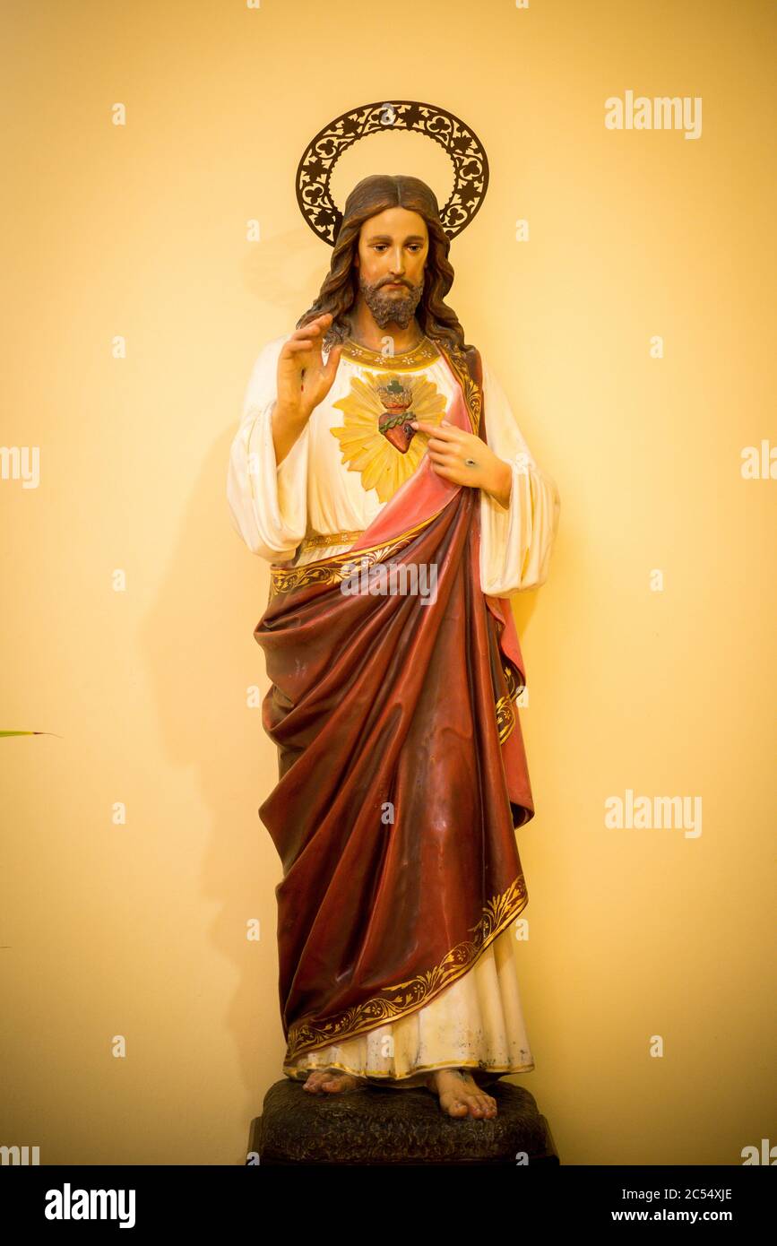 Vertical shot of a statue of Jesus Christ in a red robe on a yellow ...