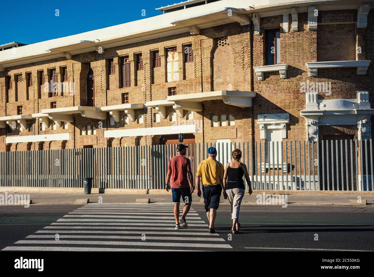 Horizontal shot of people crossing a street to a beautiful two-floor ...