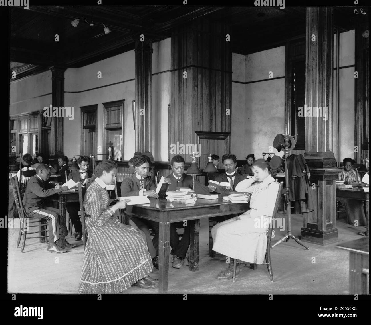Interior view of library reading room with male and female students ...