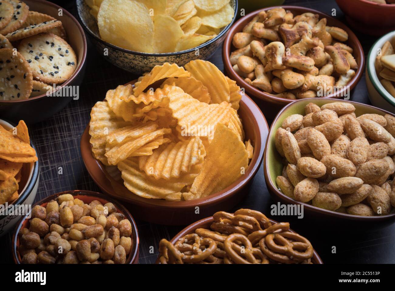 Salty snacks served as party food in ceramic bowls Stock Photo - Alamy