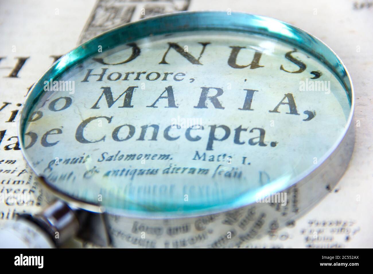 Closeup shot of a page in the Holy Bible under a magnifying glass Stock ...