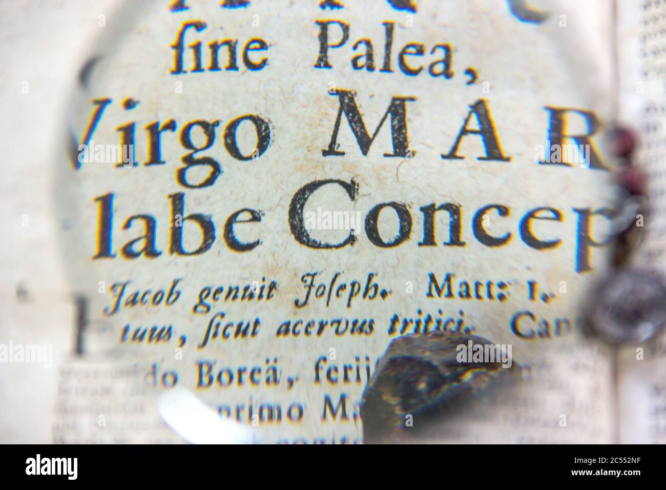 Closeup shot of a page in the Holy Bible under a magnifying glass Stock ...