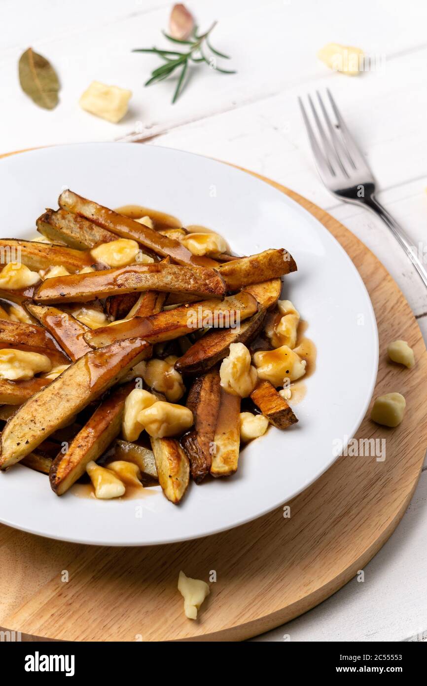 Poutine vertical portrait view. A classic fast food cuisine dish from ...