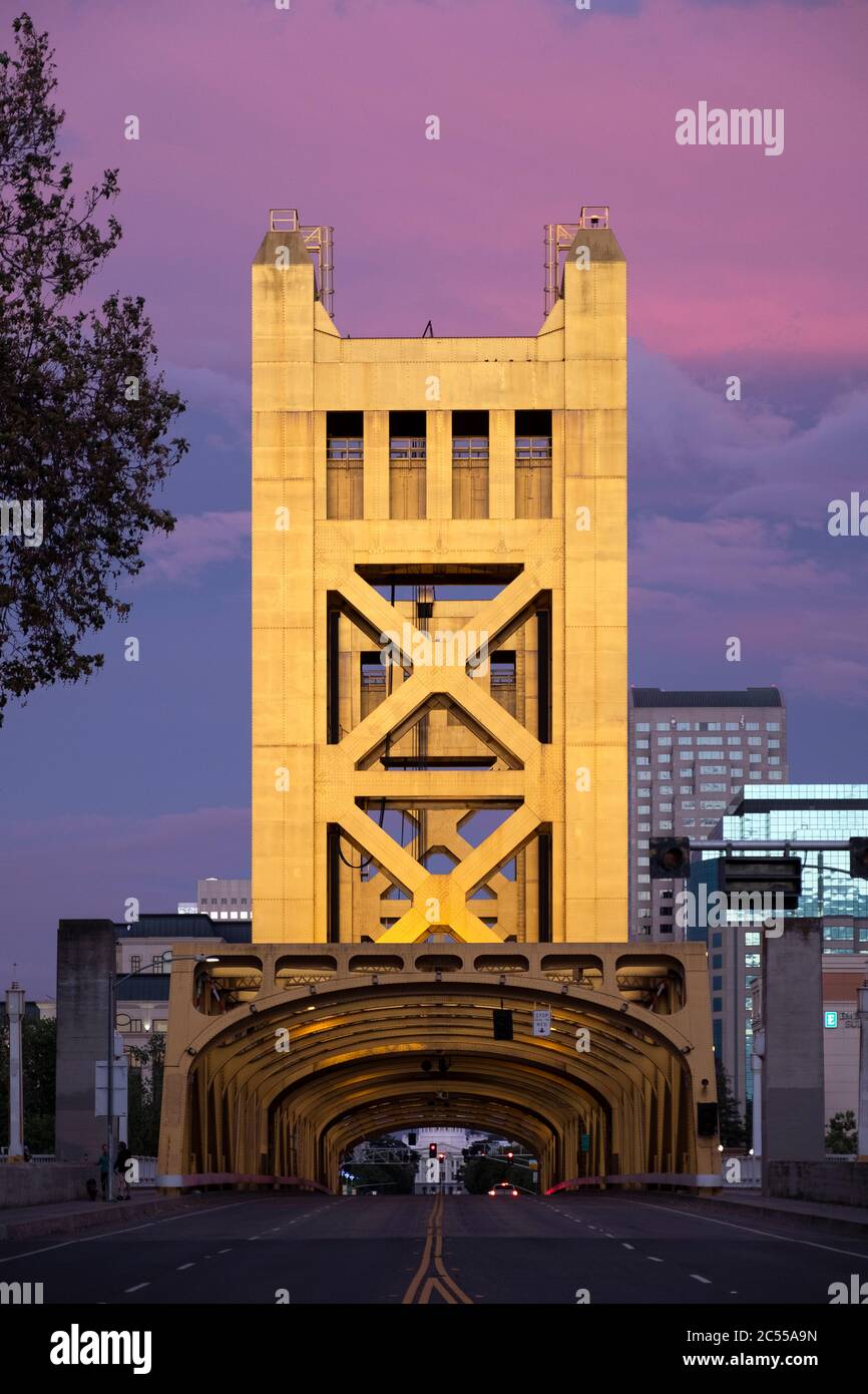 Pink sunset sky behind the golden Tower Bridge across the Sacramento ...