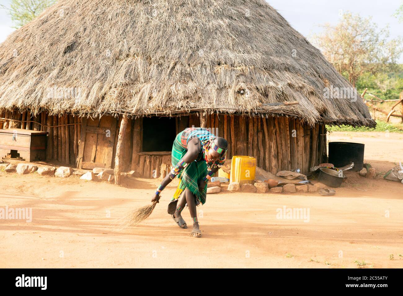 An indigenous, ethnic Hamer (Hamar) tribe woman sweeping the dirt ...