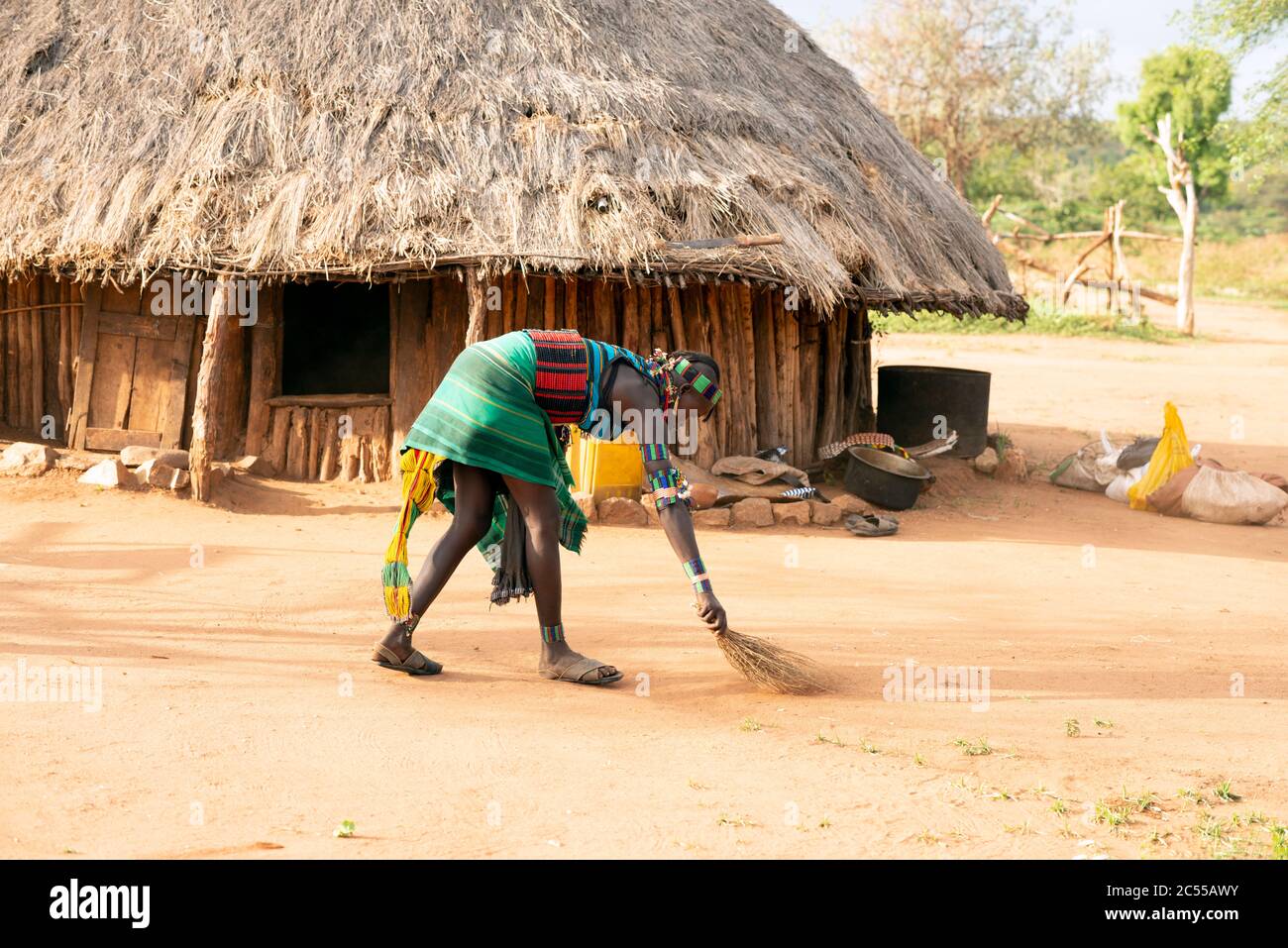 An indigenous, ethnic Hamer (Hamar) tribe woman sweeping the dirt ...