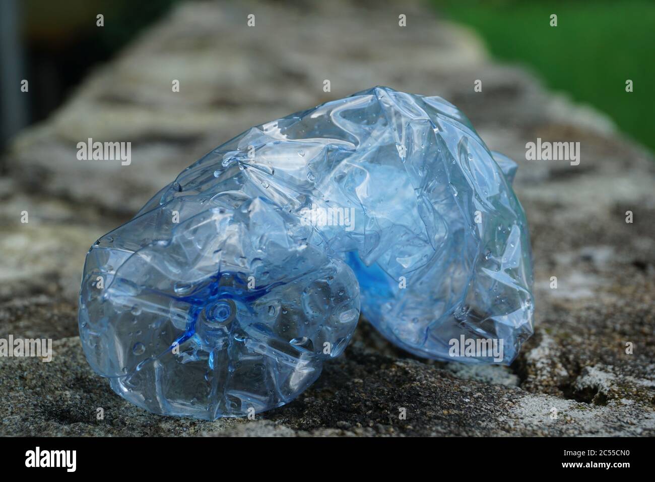 High angle shot of a crushed empty water bottle on a stone surface captured at daylight Stock ...