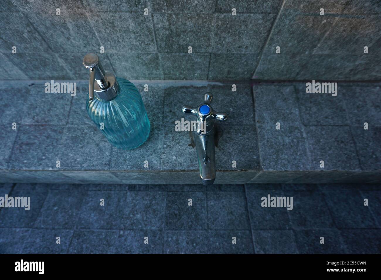 High angle shot of an empty soap container by the water tap captured in ...