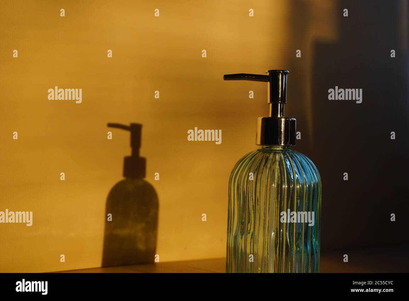 Empty soap container with its shadow on the wall captured in a bathroom ...