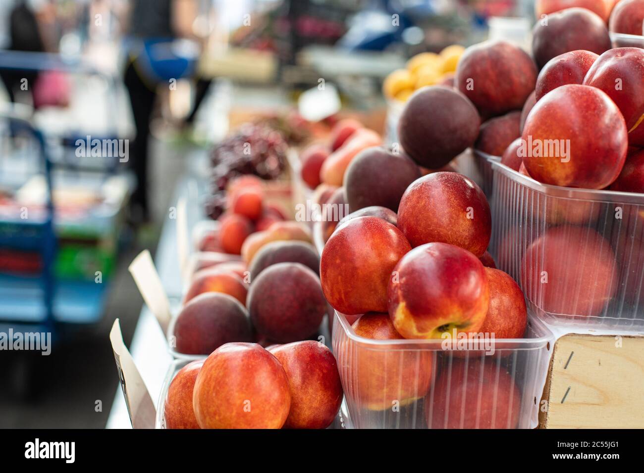 Picture of sweet, tasty and fresh peaches lying in small plastic boxes ...