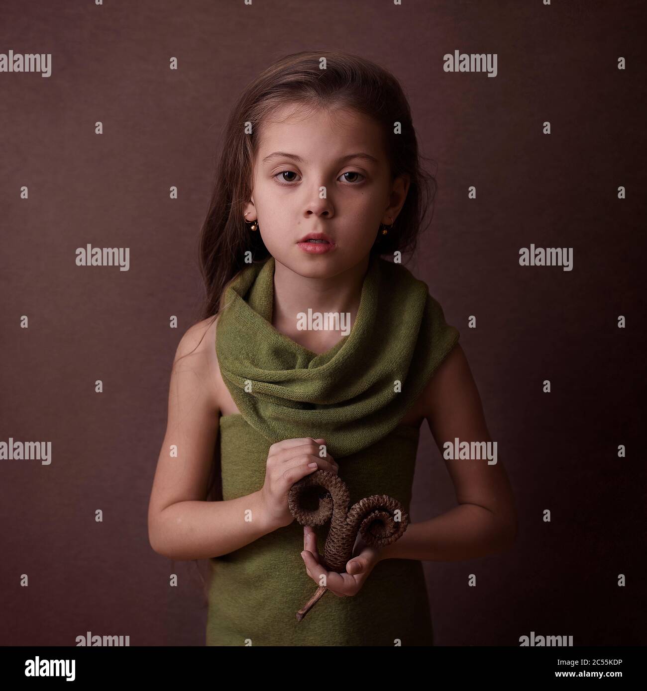a girl on a brown background holds a palm leaf signifying the zodiac s ...
