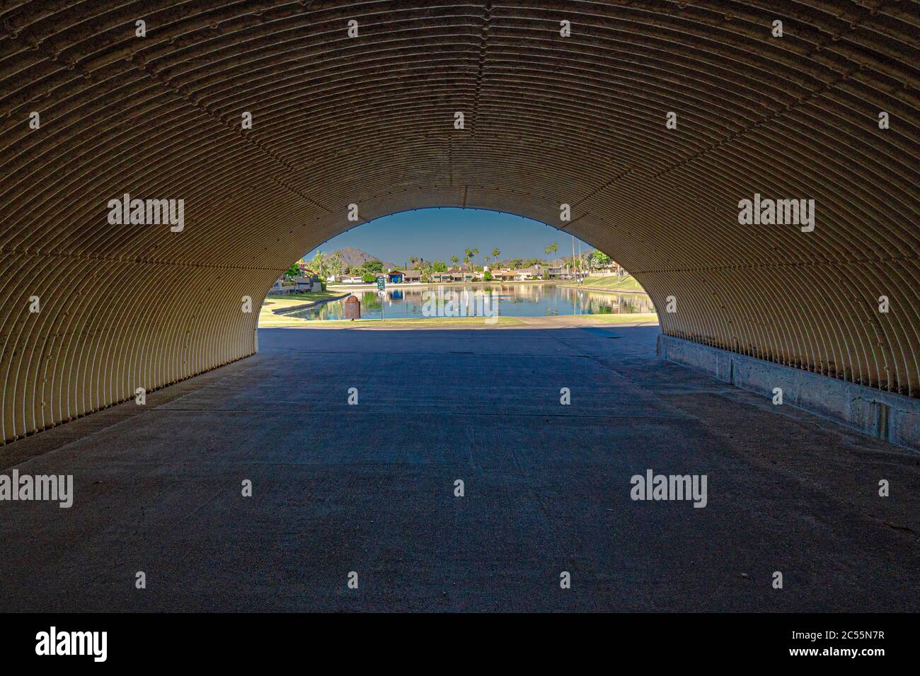 Beautiful tunnel with an opening view of a reflective park pond Stock ...