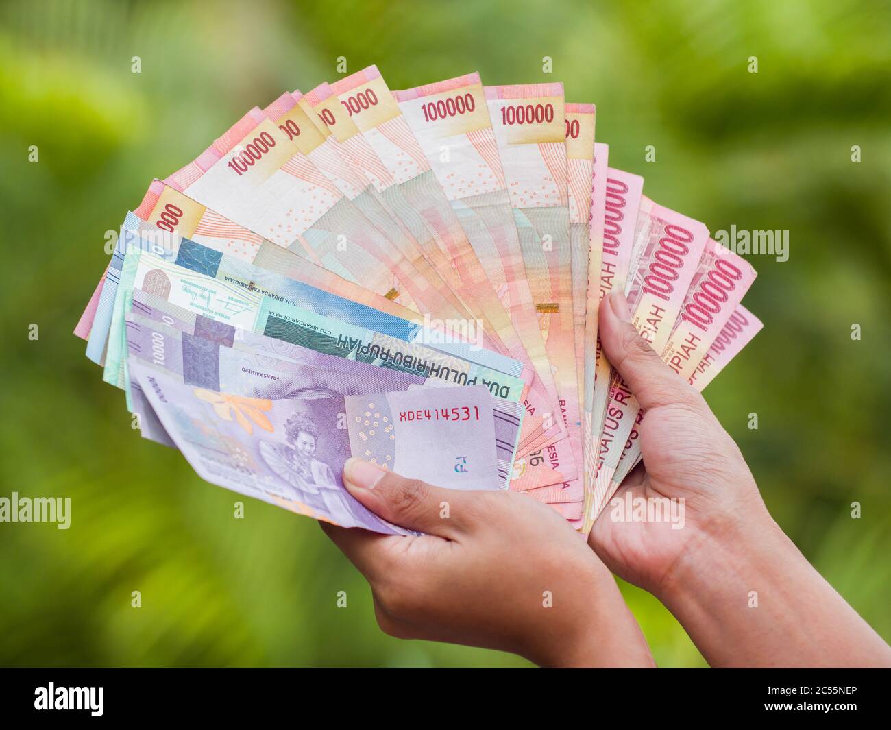 Indonesian money in the hands of an asian girl Stock Photo - Alamy