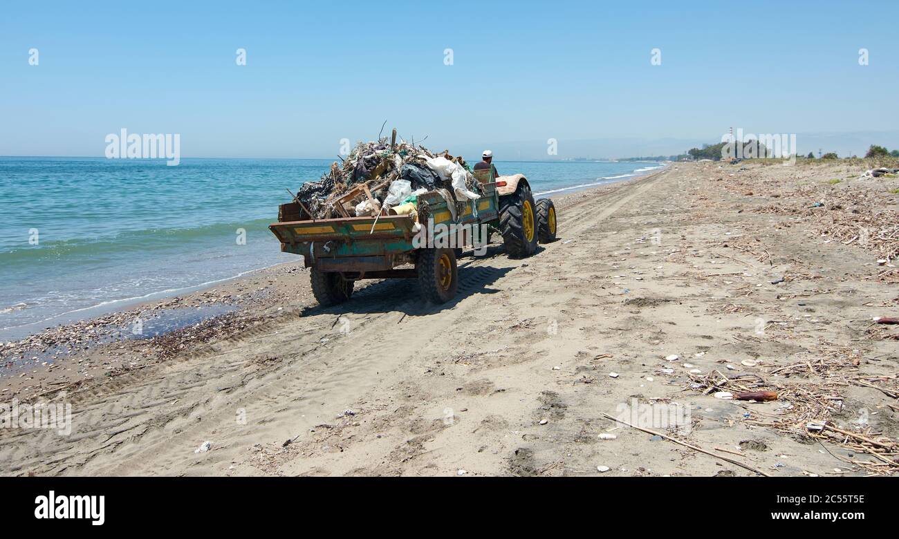Man driving a tractor while collecting garbage on a seashore Stock ...