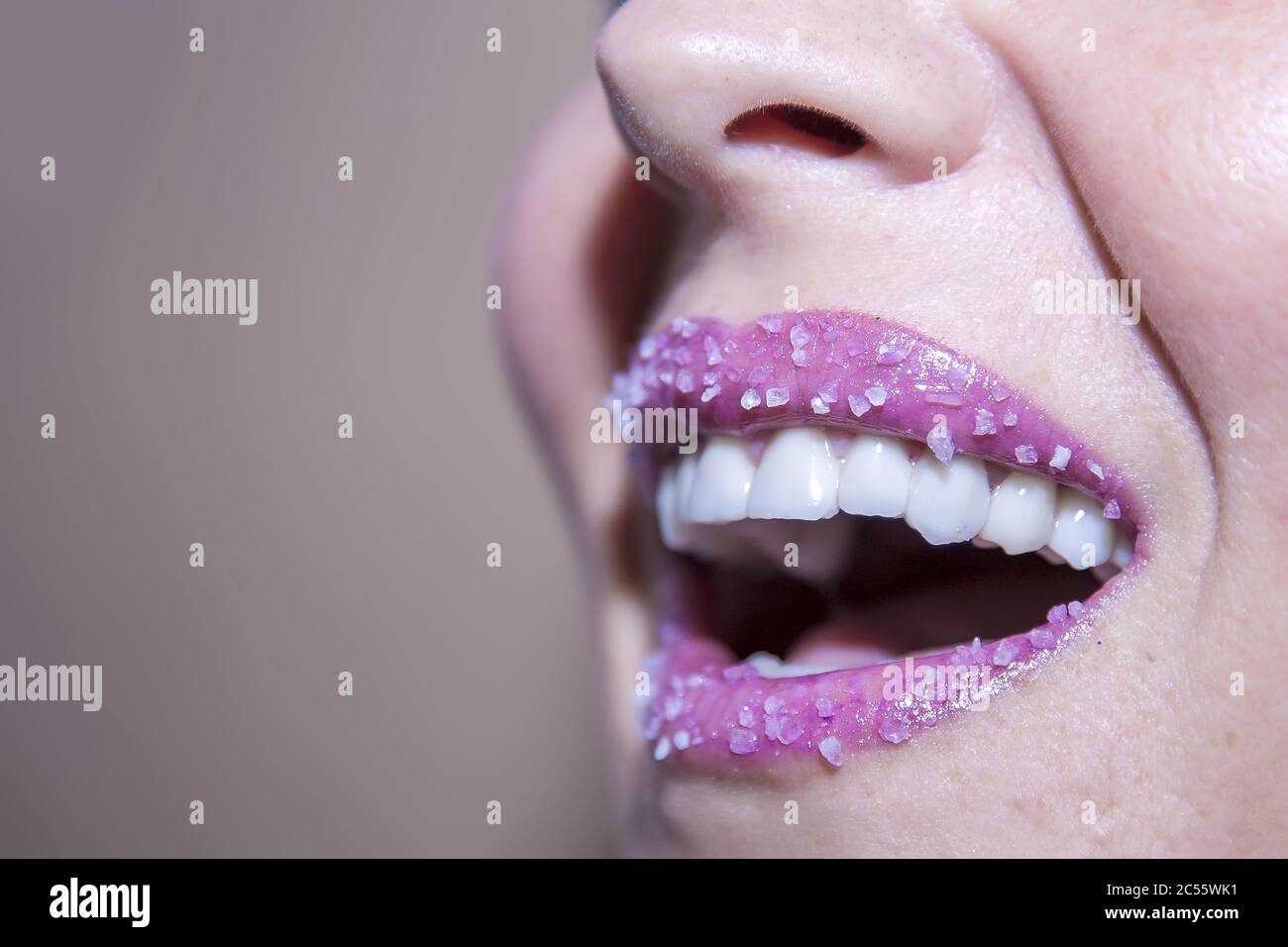 Closeup of a smiling person with white teeth and purple lips with ...