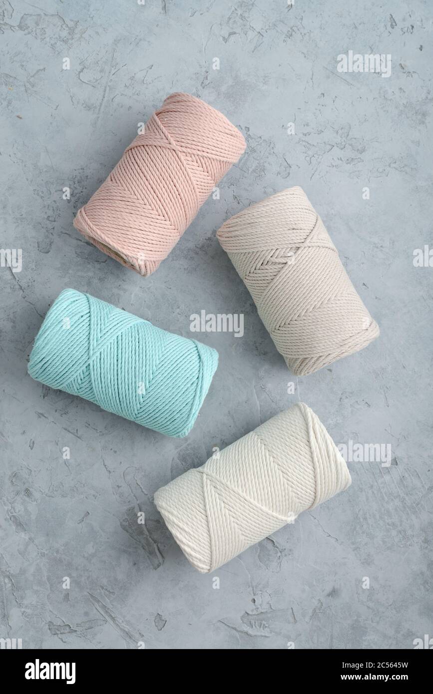 Macrame cotton cord spools in different pastel colors on grey concrete ...