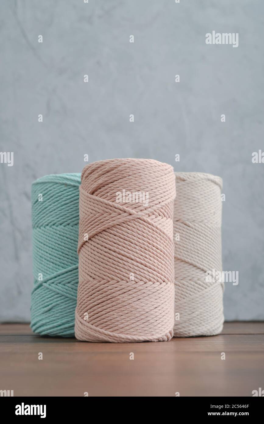 Macrame cotton cord spools in different pastel colors on grey concrete ...