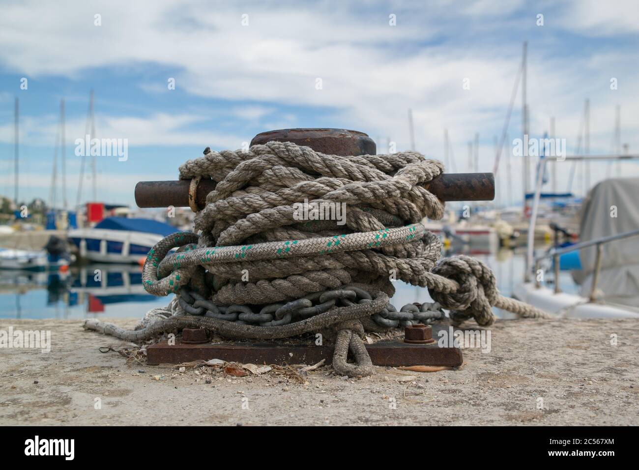 Ropes of a ship wrapped around a mooring bollard on the pier Stock ...