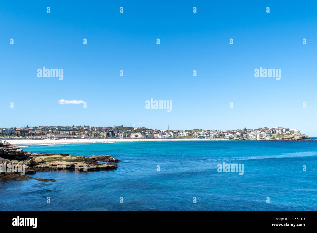 Gorgeous view of Bondi Beach in the summer. The ocean is deep blue and ...