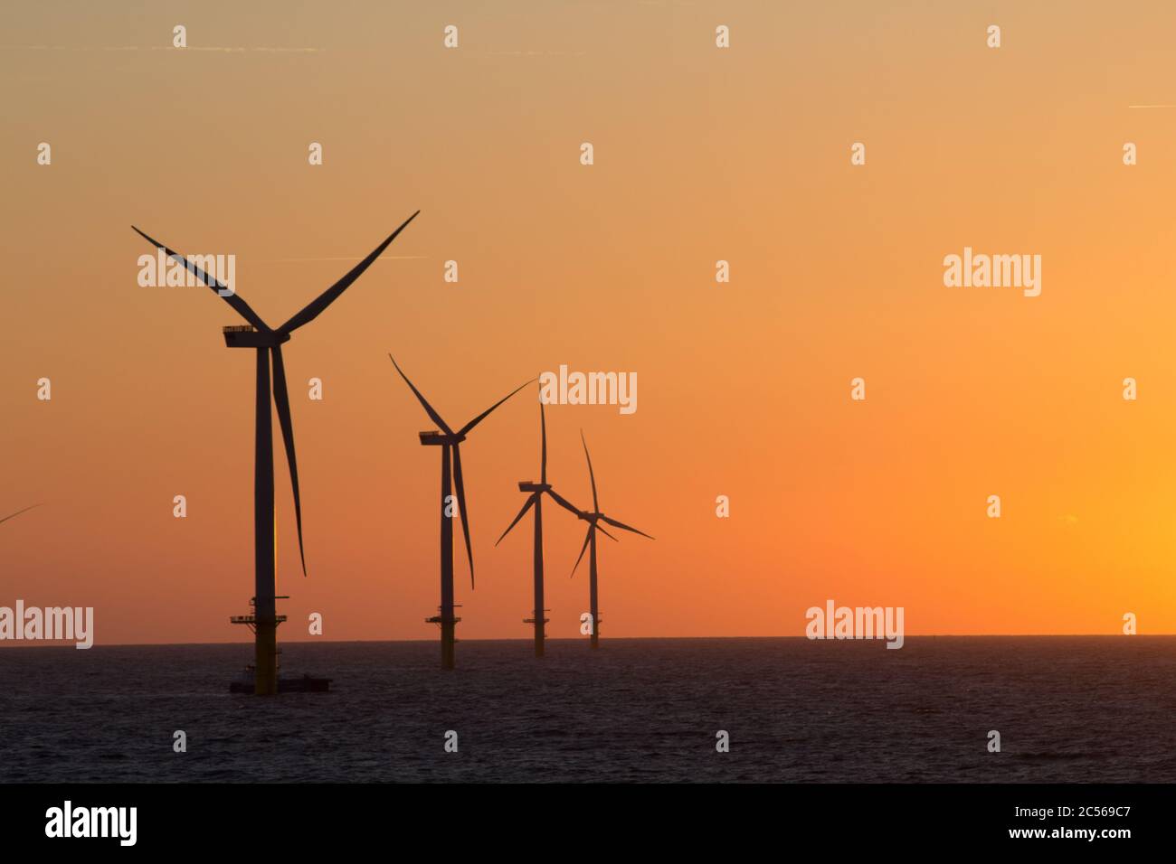 Beautiful view of wind generators in a sea at the sunset Stock Photo ...