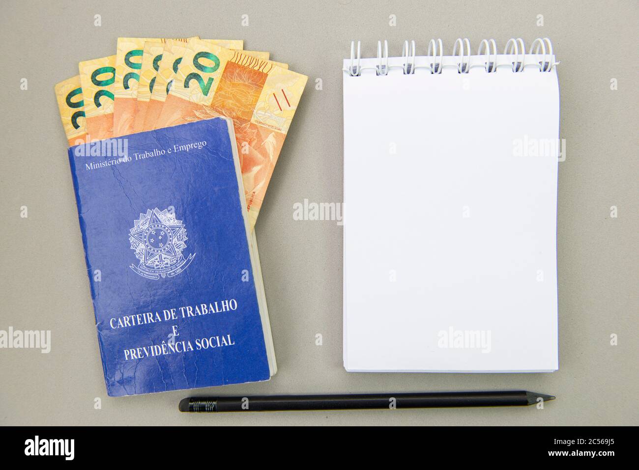 Top view of working card with money bills inside next to a notepad on ...