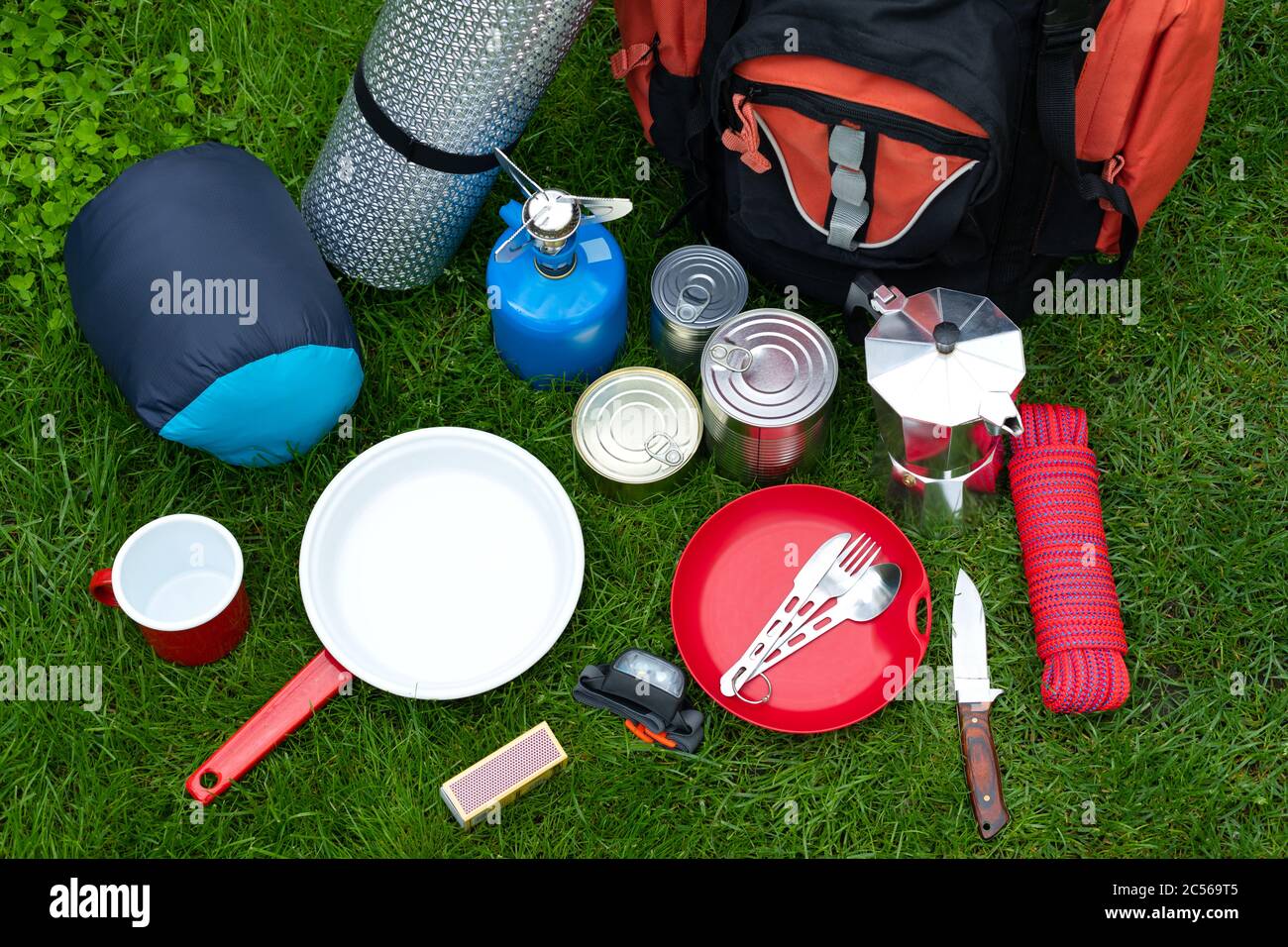 Picture of camping tools on the grass - backpack, tent, gas tank, cans ...