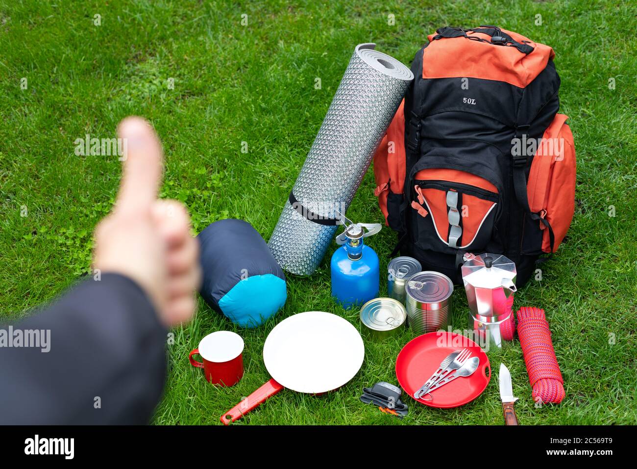 Picture of camping tools on the grass - backpack, tent, gas tank, cans ...
