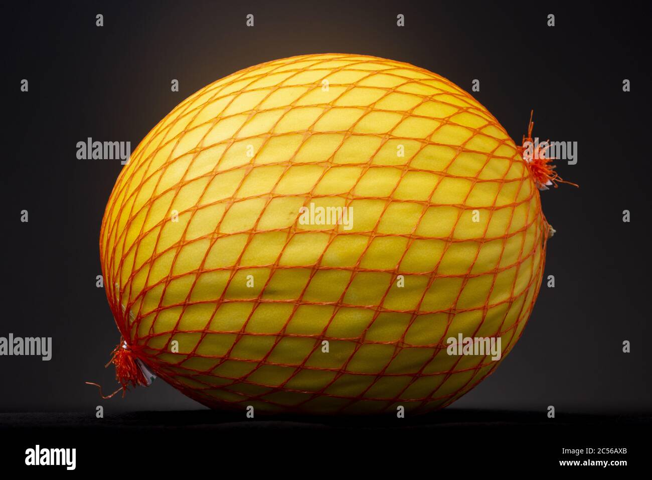 Texture low key closeup of canary melon in plastic net Stock Photo - Alamy