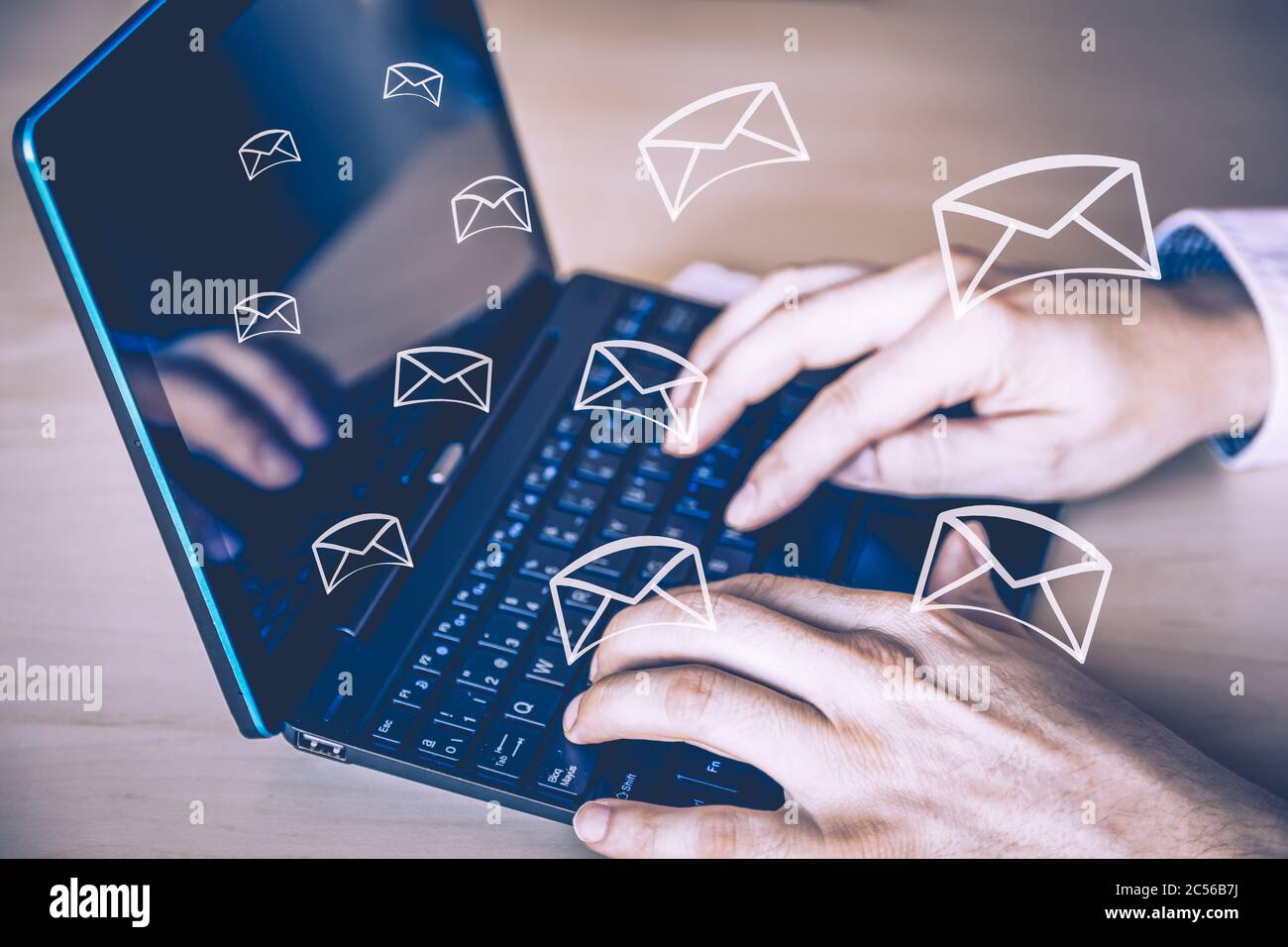Closeup of a person's hands writing an e-mail on a laptop with letter ...